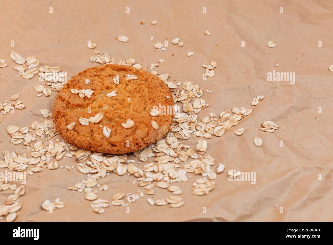 oatmeal cookies and scattered oatmeal on crumpled paper background ...
