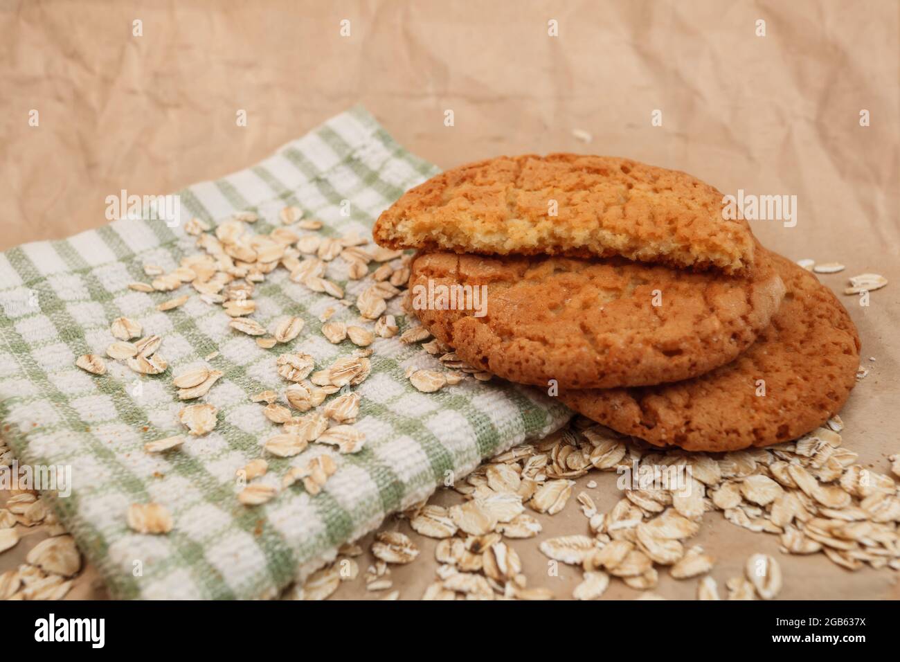 oatmeal cookies and scattered oatmeal on crumpled paper background ...