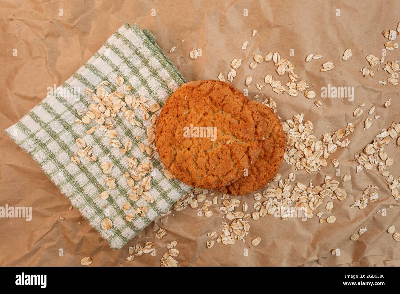 oatmeal cookies and scattered oatmeal on crumpled paper background ...