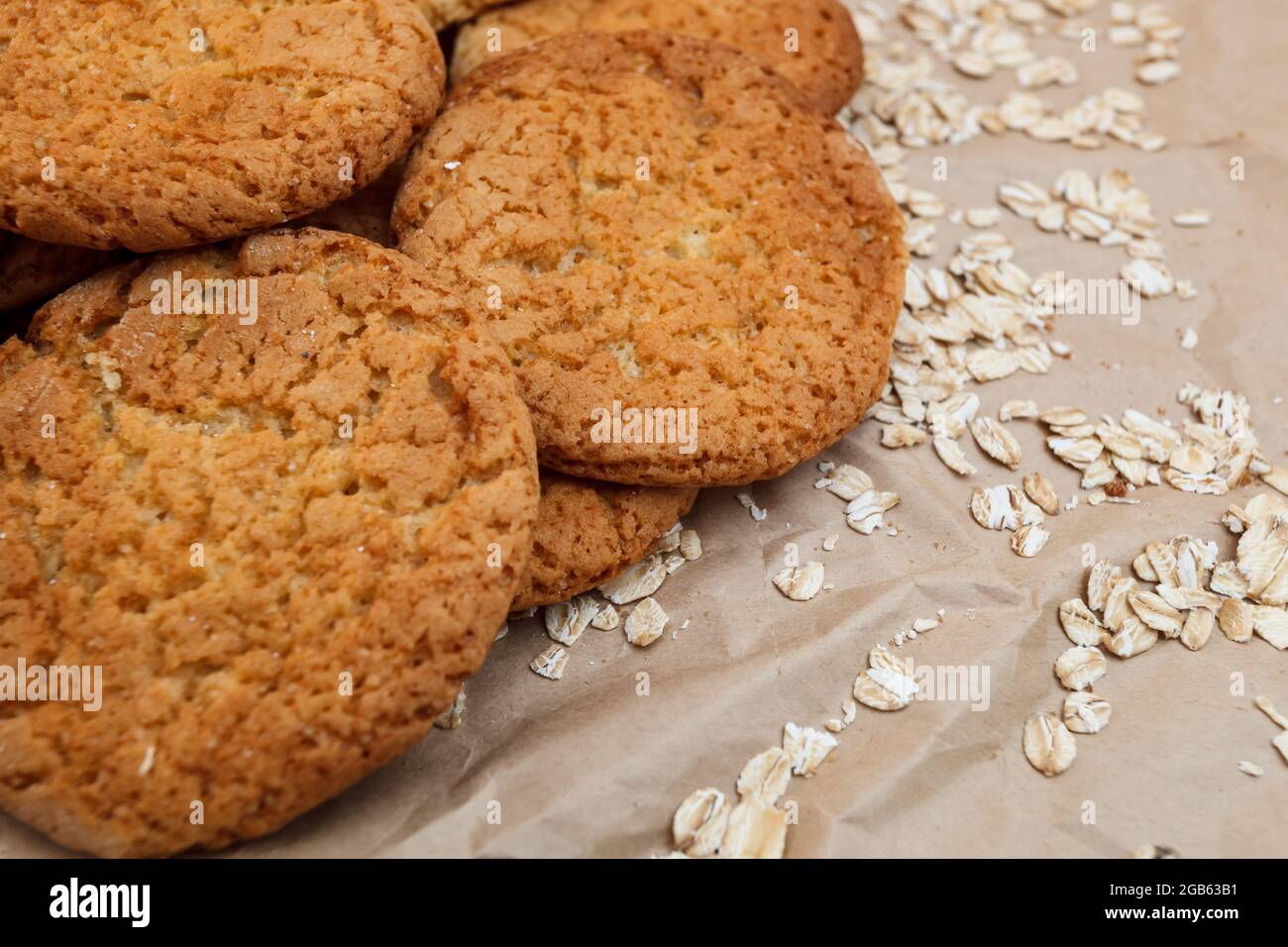 oatmeal cookies and scattered oatmeal on crumpled paper background ...