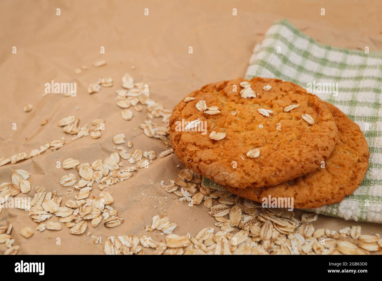 oatmeal cookies and scattered oatmeal on crumpled paper background ...