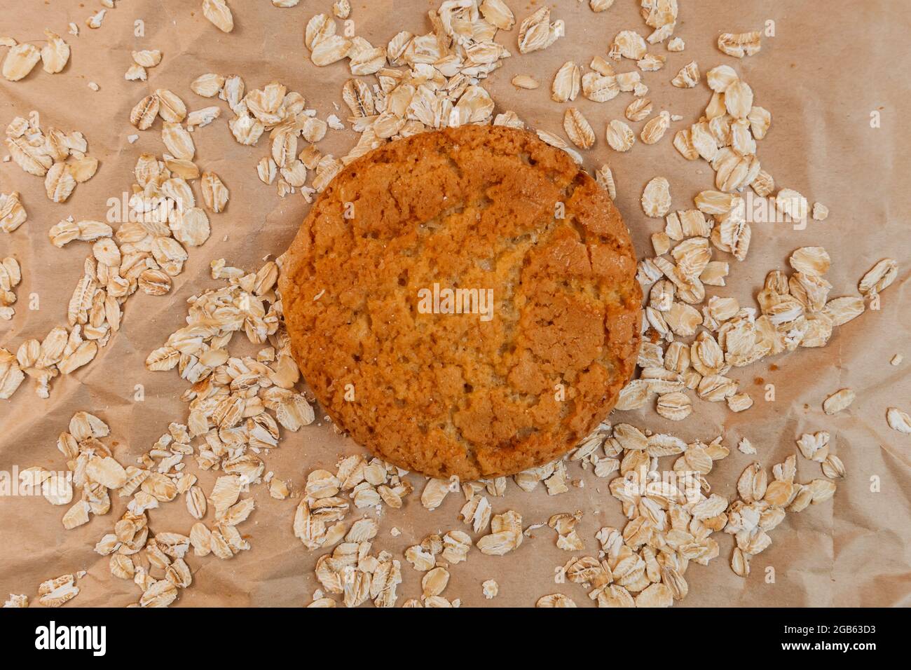 oatmeal cookies and scattered oatmeal on crumpled paper background ...