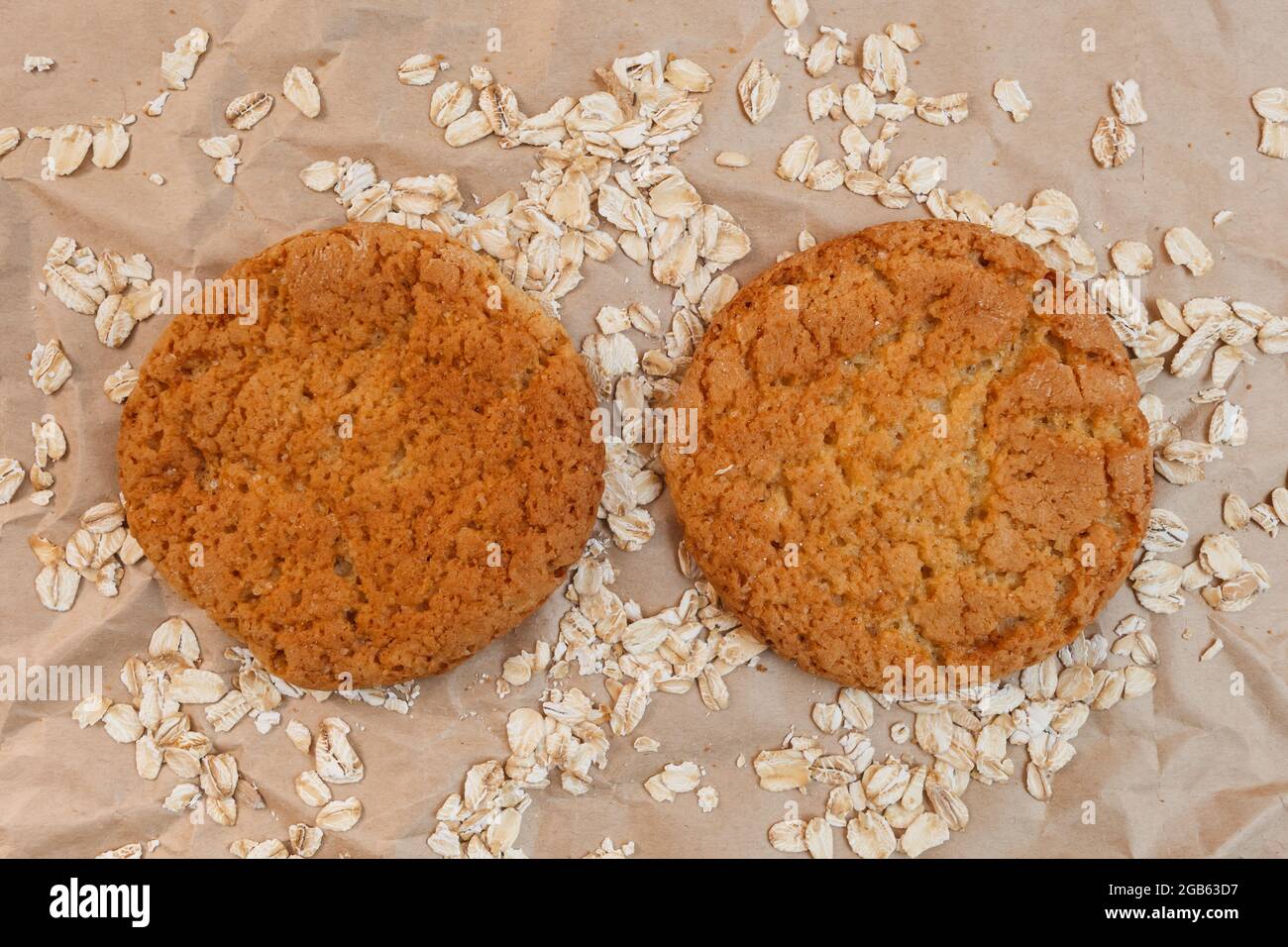 oatmeal cookies and scattered oatmeal on crumpled paper background ...