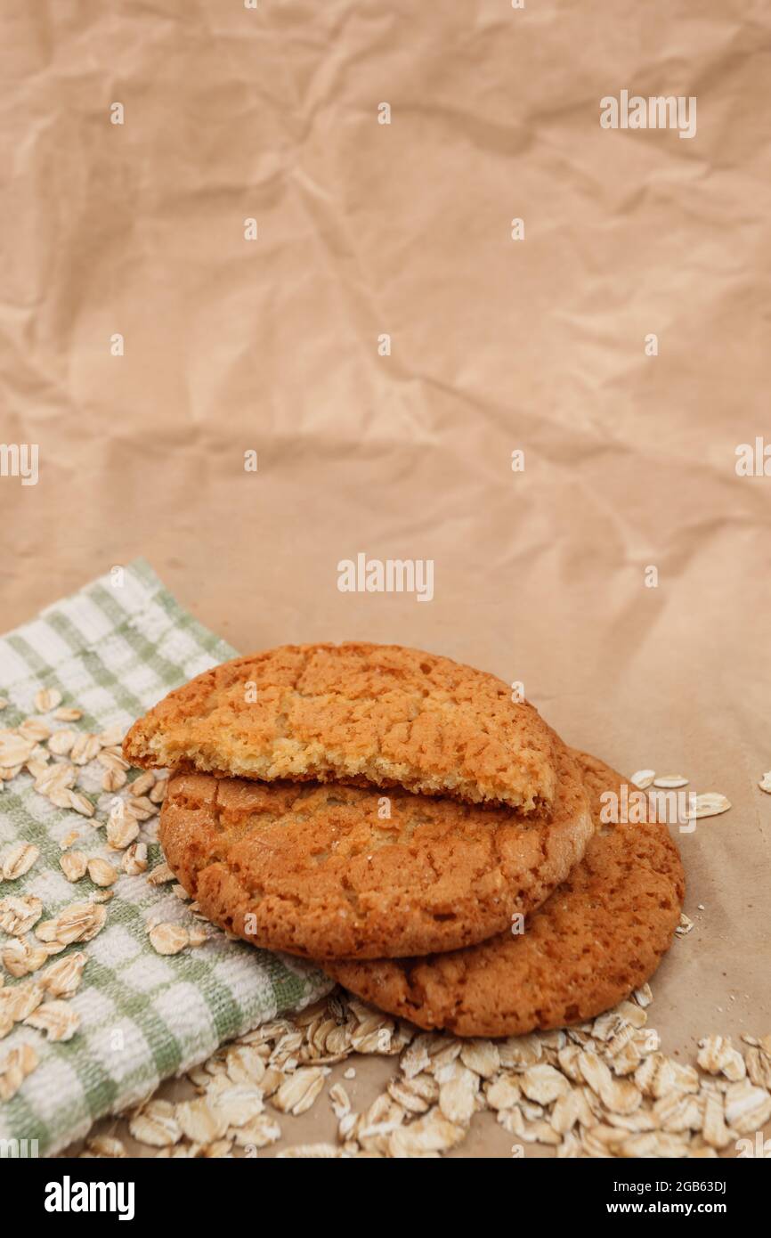 oatmeal cookies and scattered oatmeal on crumpled paper background ...