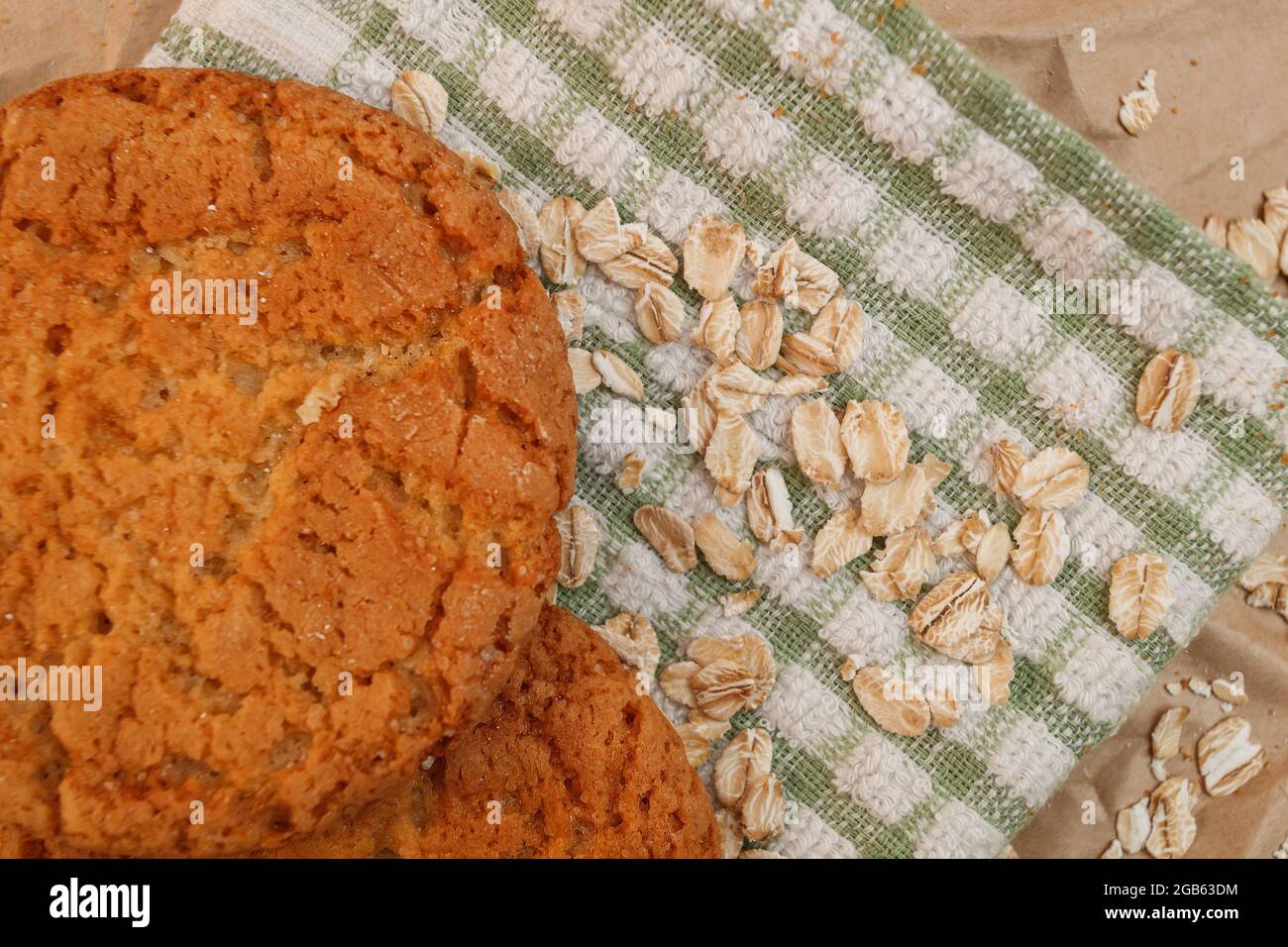 oatmeal cookies and scattered oatmeal on crumpled paper background ...
