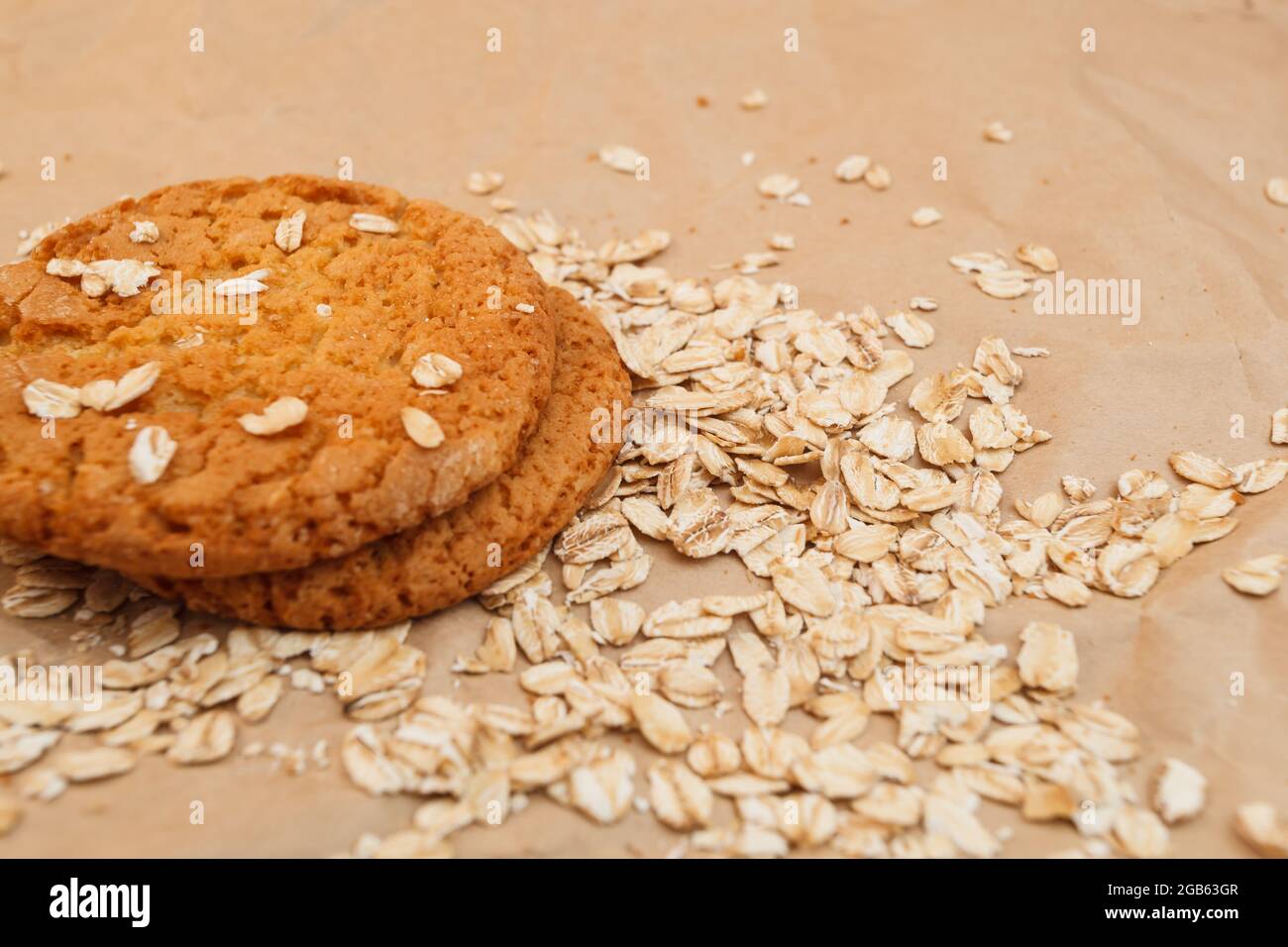 oatmeal cookies and scattered oatmeal on crumpled paper background ...