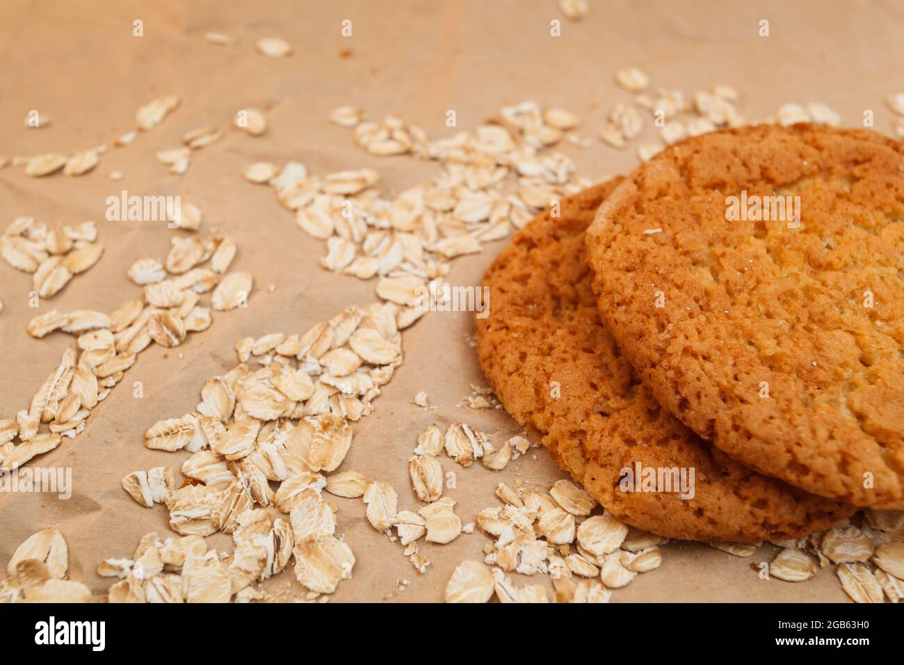 oatmeal cookies and scattered oatmeal on crumpled paper background ...