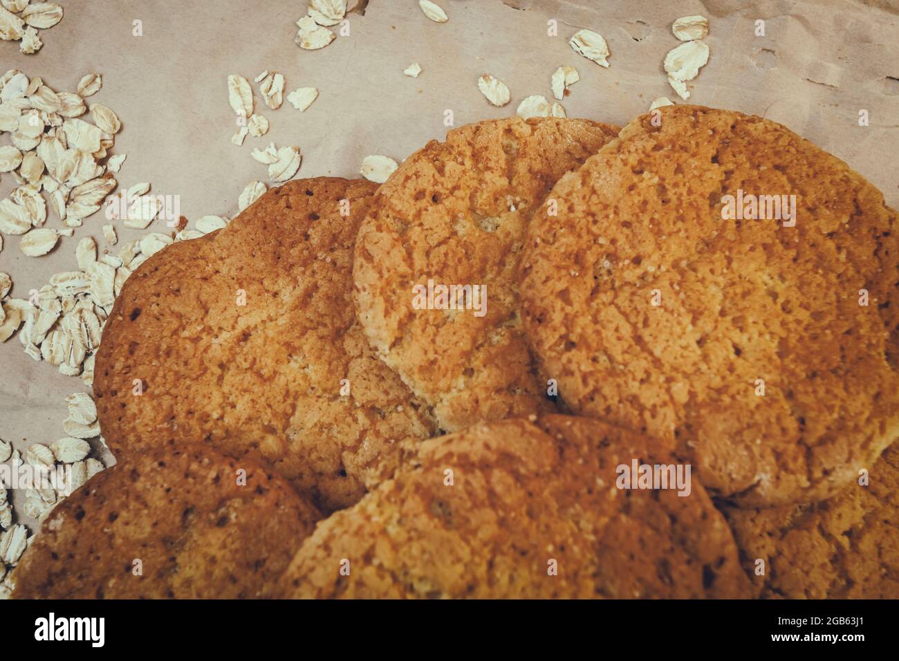 oatmeal cookies and scattered oatmeal on crumpled paper background ...