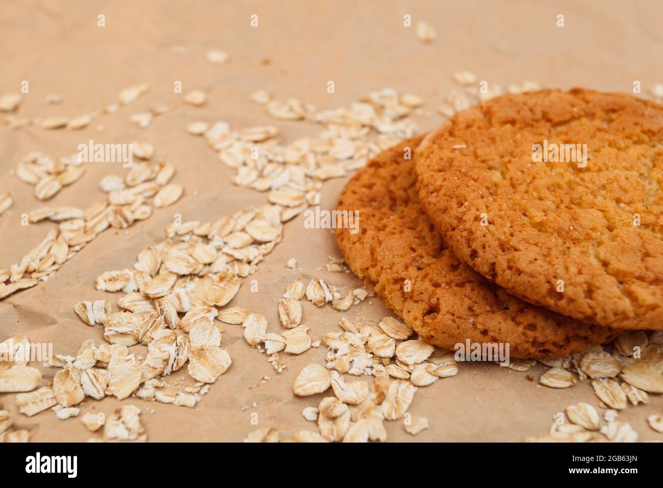 oatmeal cookies and scattered oatmeal on crumpled paper background ...