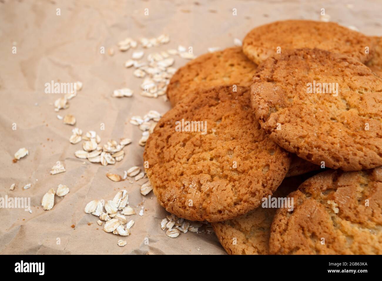 oatmeal cookies and scattered oatmeal on crumpled paper background ...