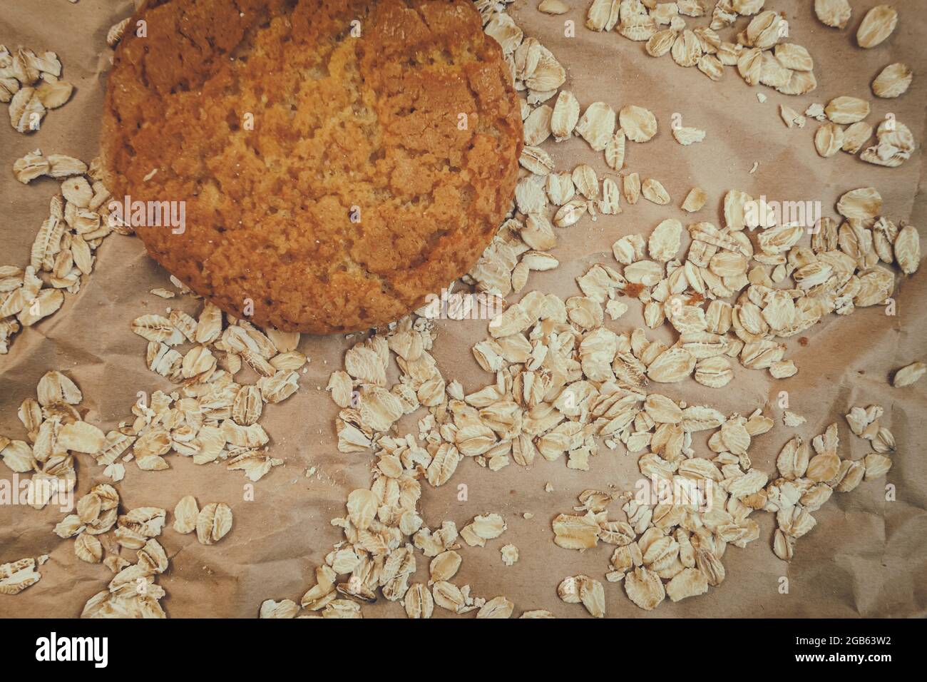 oatmeal cookies and scattered oatmeal on crumpled paper background ...