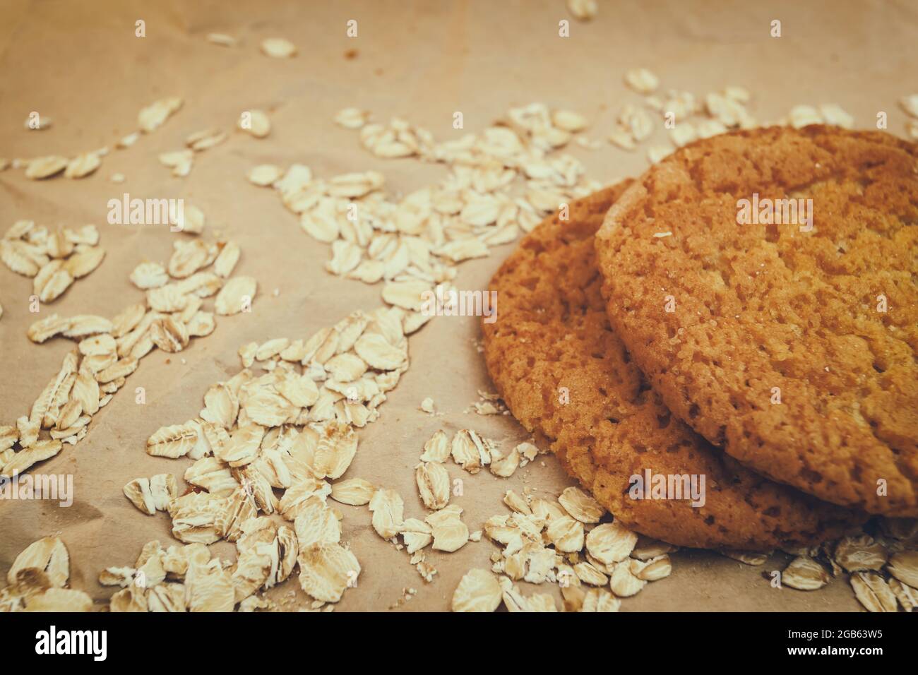 oatmeal cookies and scattered oatmeal on crumpled paper background ...