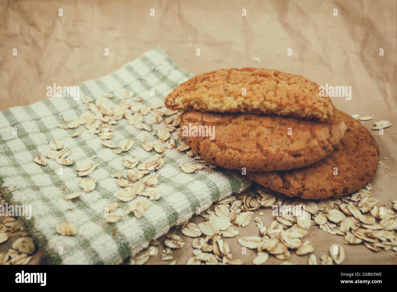 oatmeal cookies and scattered oatmeal on crumpled paper background ...