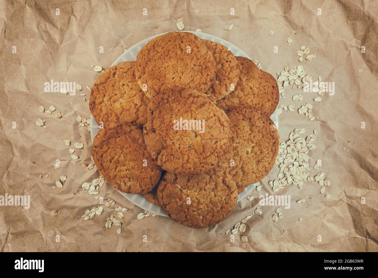 oatmeal cookies and scattered oatmeal on crumpled paper background ...