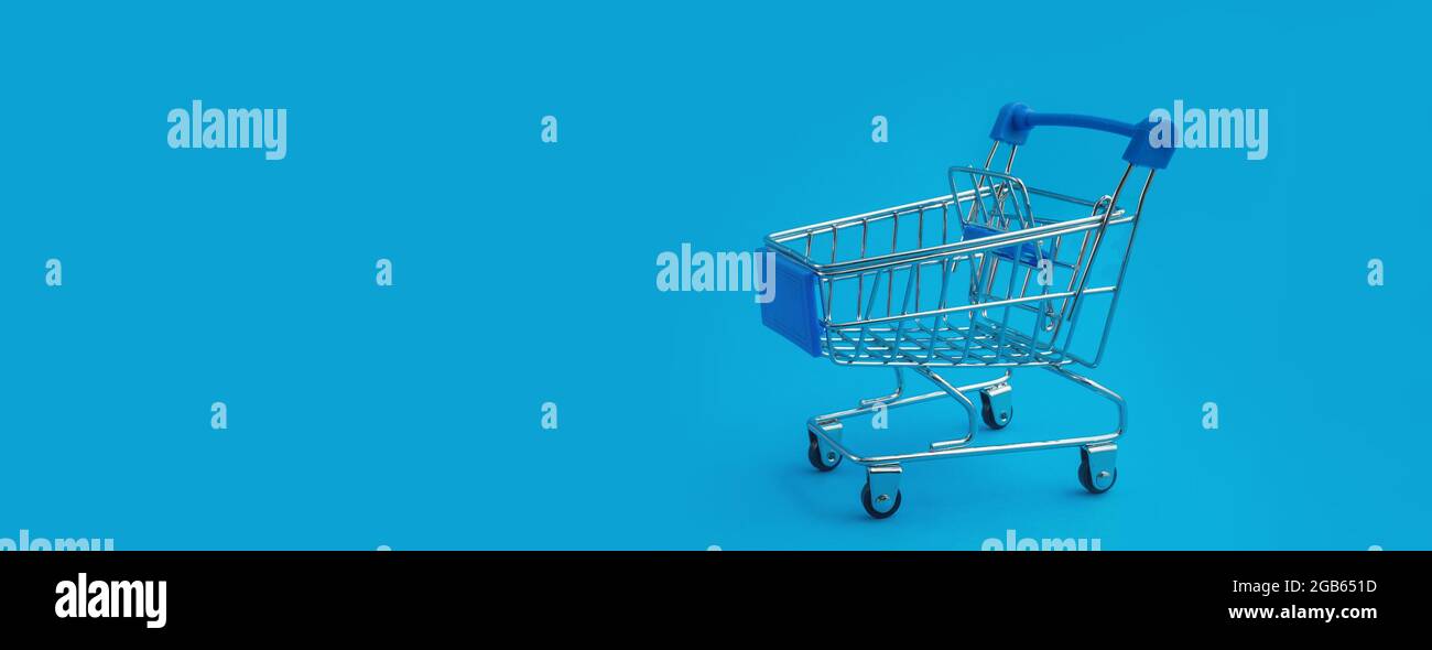 supermarket trolley on blue panorama background Stock Photo - Alamy