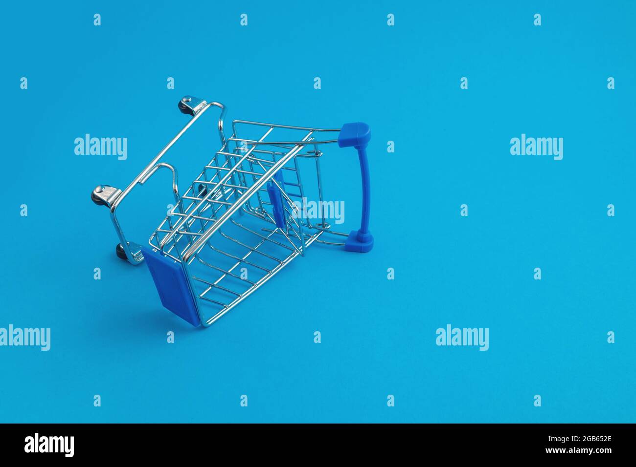 supermarket trolley on blue background Stock Photo - Alamy