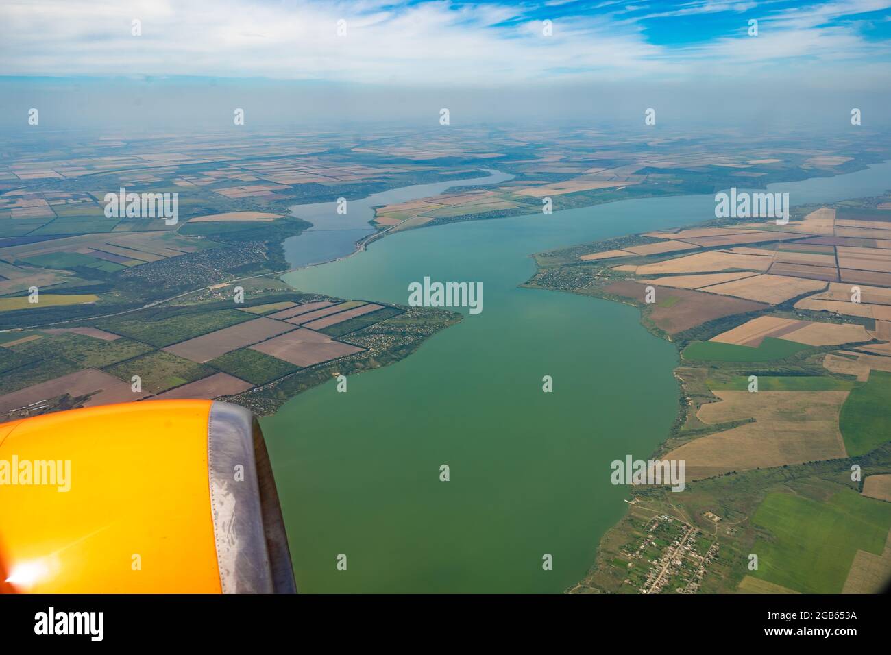 Land view through the airplane window. Fields, roads, rivers from a ...