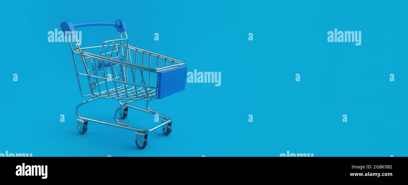 supermarket trolley on blue panorama background Stock Photo - Alamy