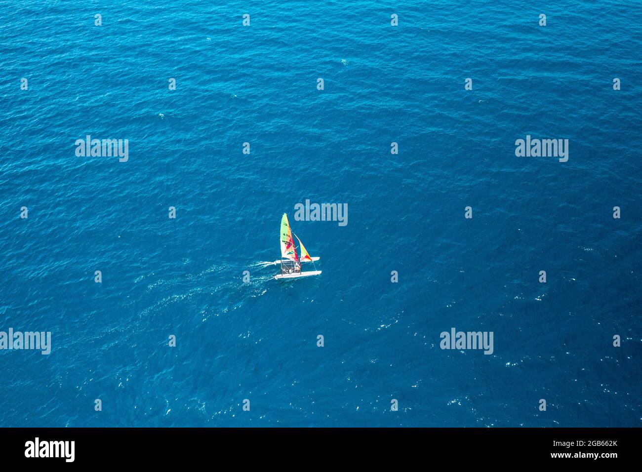 Aerial view of portable sailboat windsurfing catamaran in blue water of ...