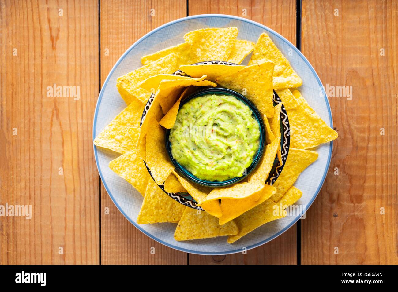 Guacamole with tortilla chips on wooden boards. Nachos chips and ...