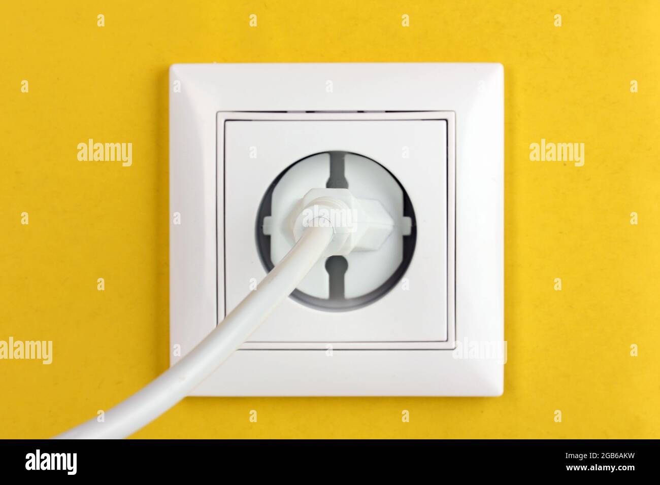 White electric socket with plug on the wall Stock Photo - Alamy