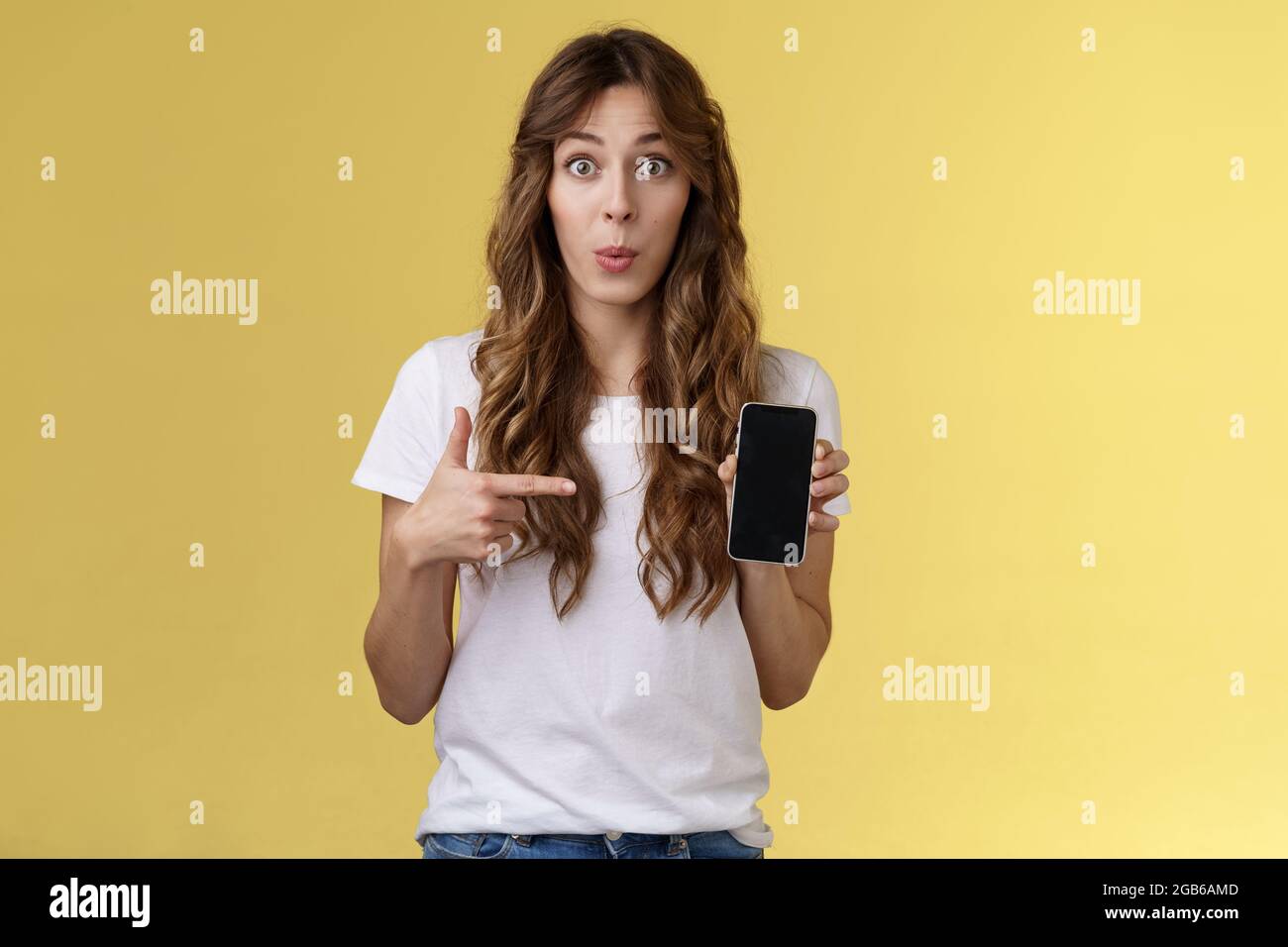 Intriguing app check out. Enthusiastic surprised attractive girlfriend gossiping friend new ...