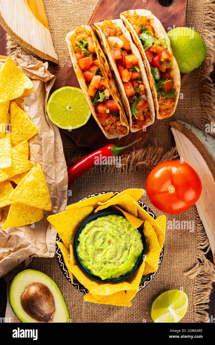 Mexican food table with nachos, guacamole, tacos and ingredients ...
