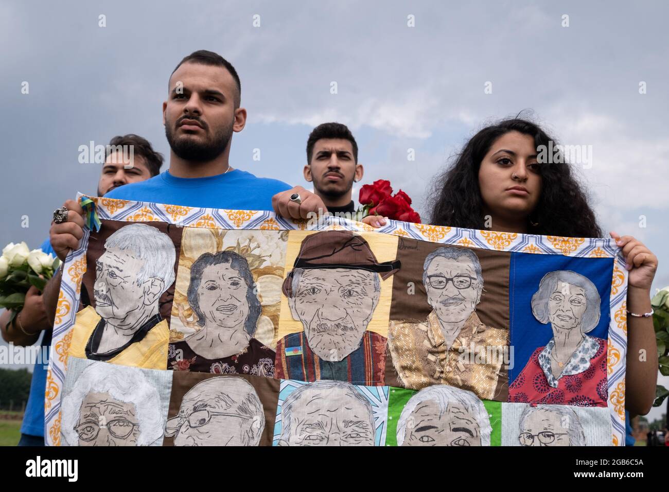 A group of Gypsies holding a poster walk along the path at the former ...
