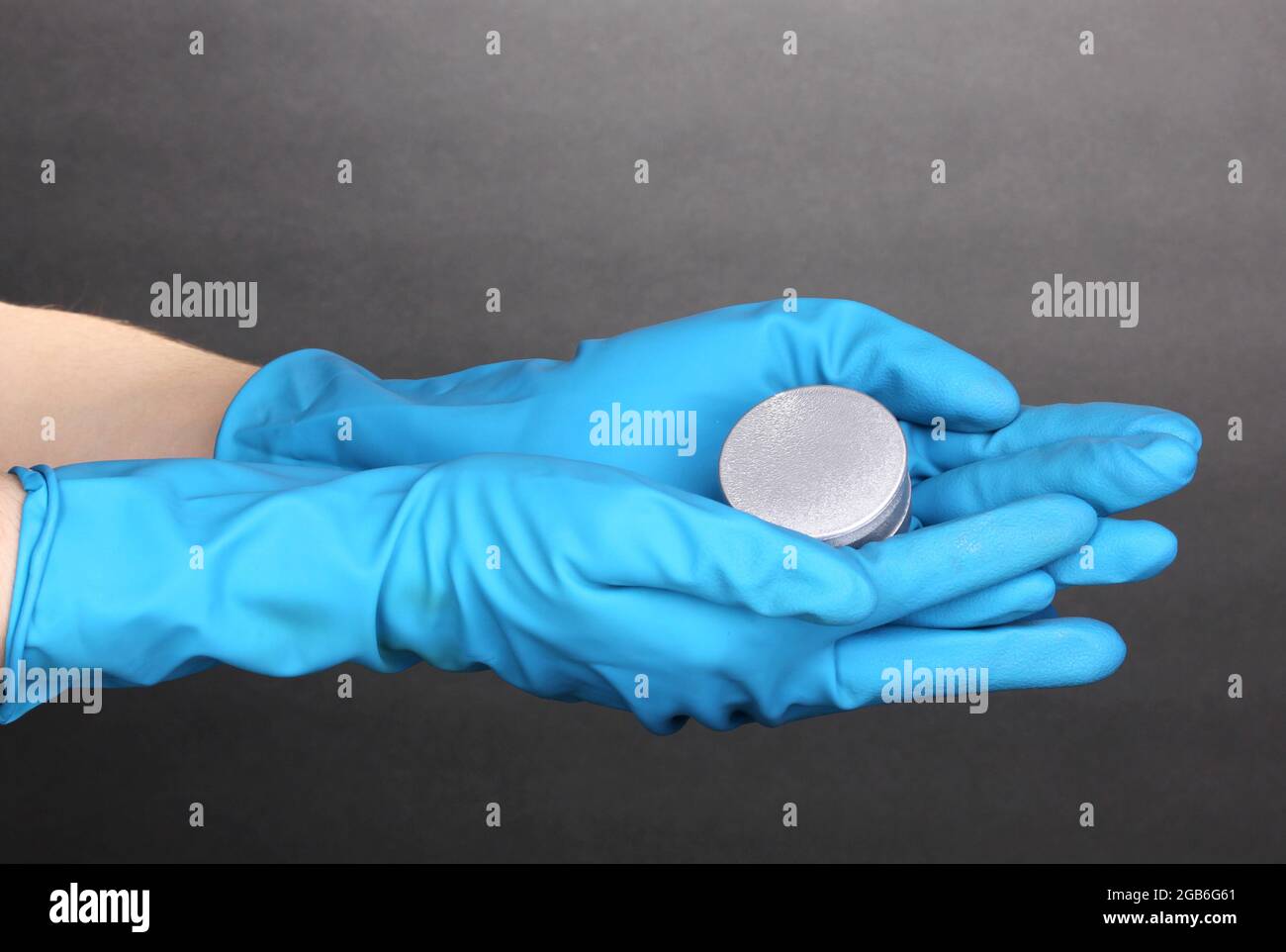 Uranium in hands on grey background Stock Photo - Alamy