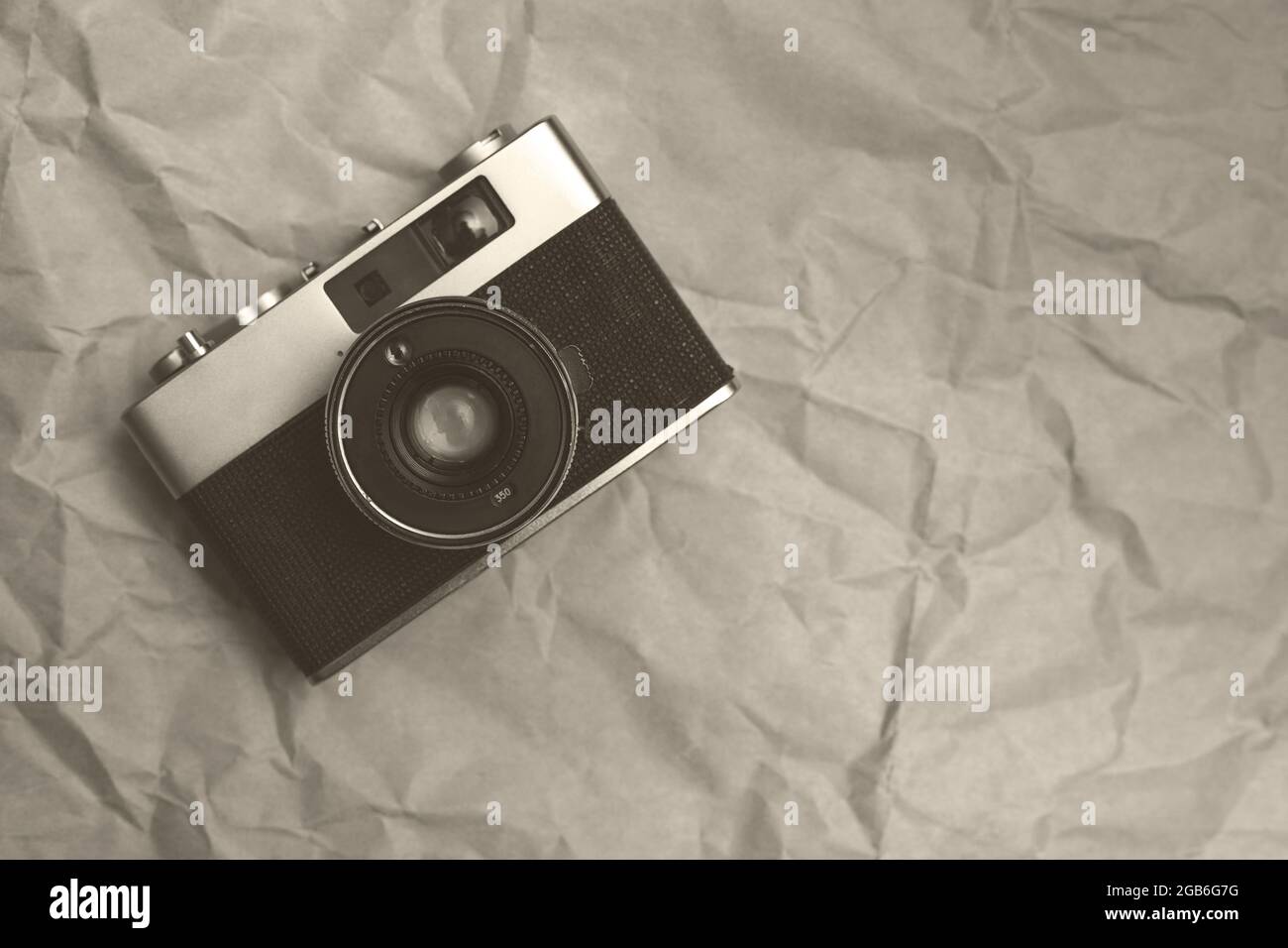 Vintage film camera on crumpled paper background. FED Mikron-2 ...