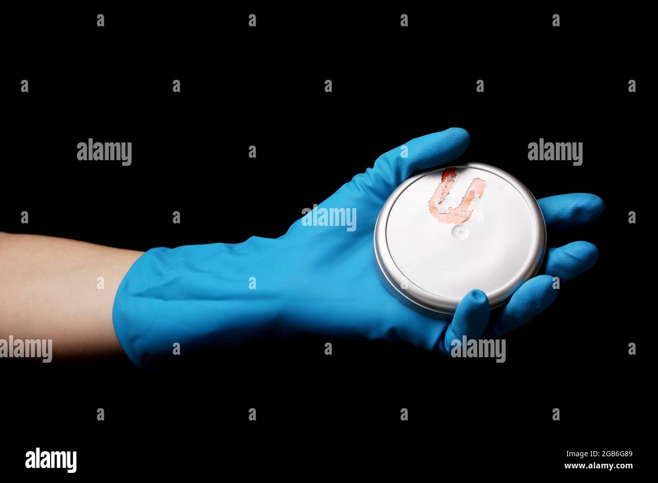 Uranium in hand isolated on black Stock Photo - Alamy