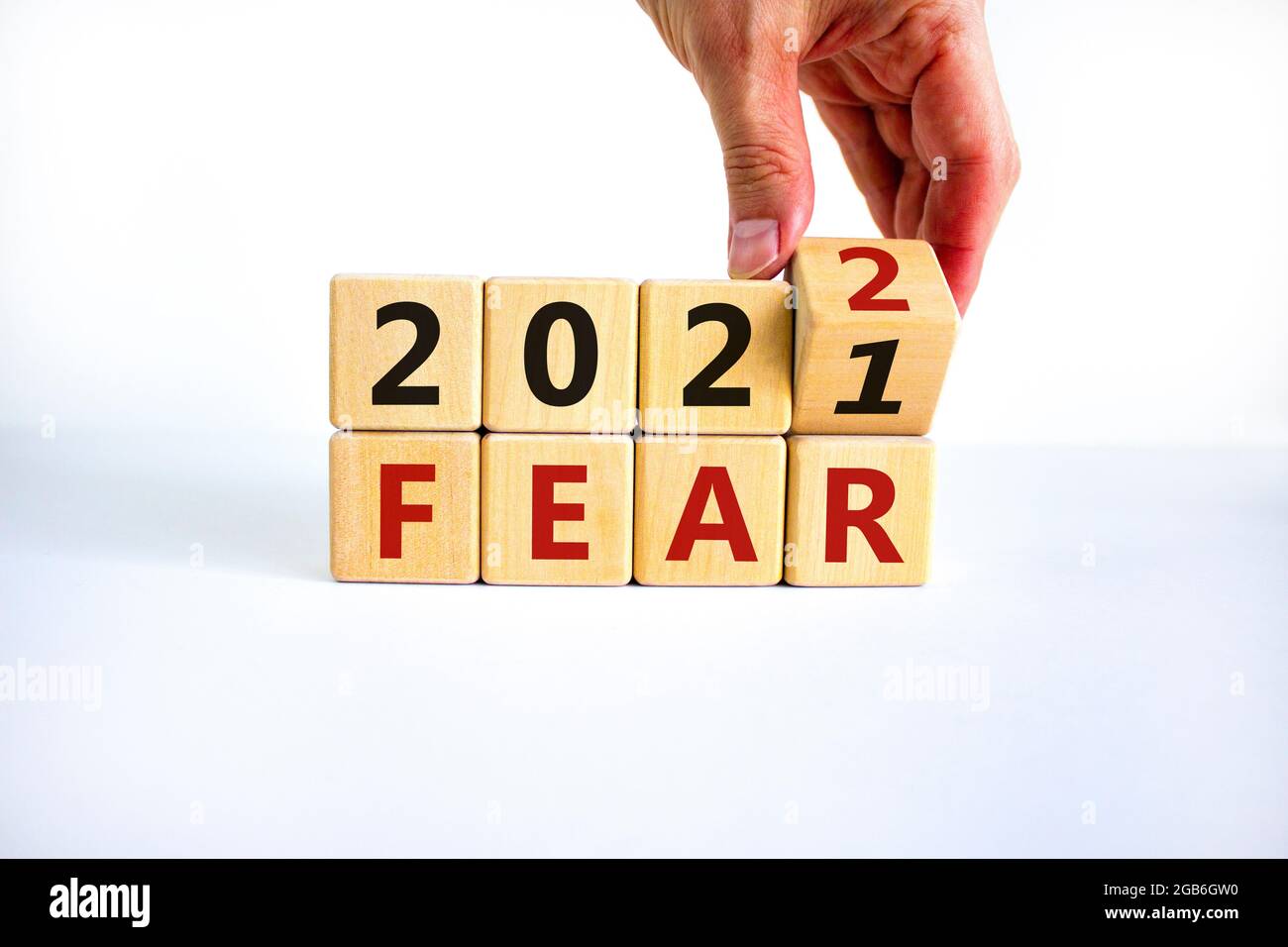 2022 fear new year symbol. Businessman turns a wooden cube and changes words 'Fear 2021' to ...