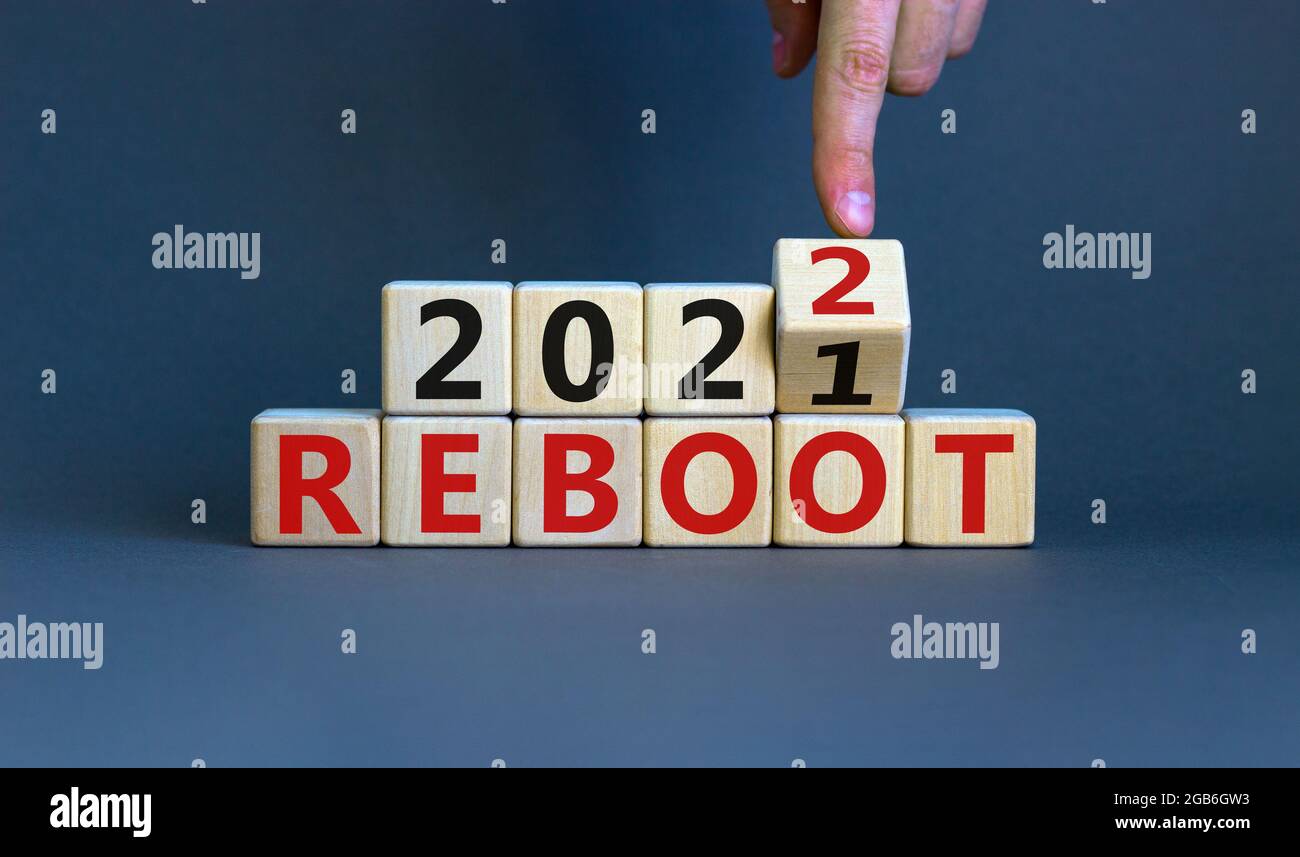 2022 reboot new year symbol. Businessman turns a wooden cube and ...