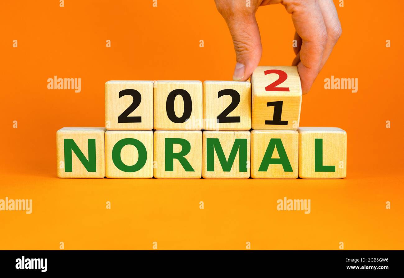 Symbol of covid-19 normal in 2022. Doctor turns a wooden cube and ...