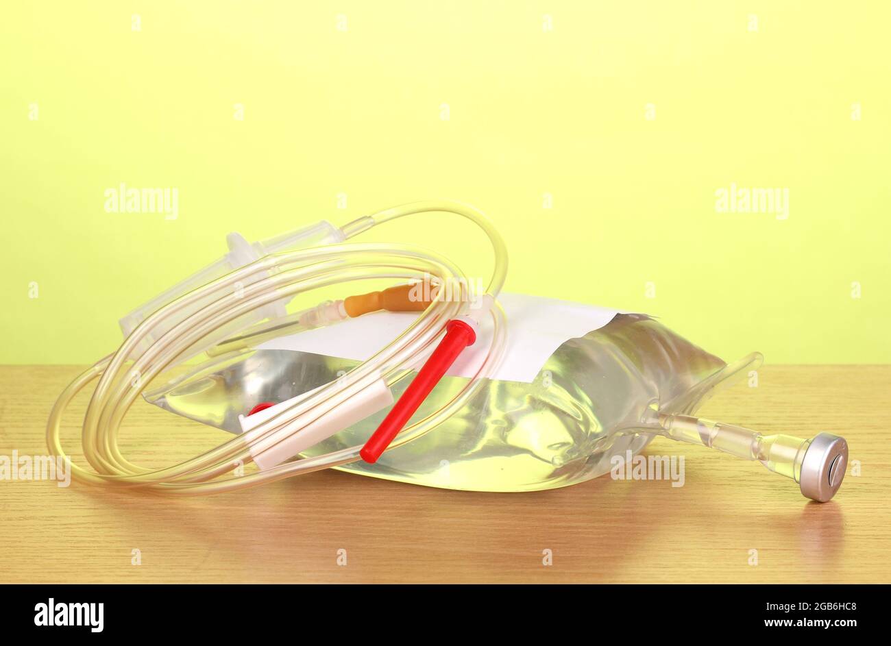 Bag of intravenous antibiotics and plastic infusion set on wooden table ...