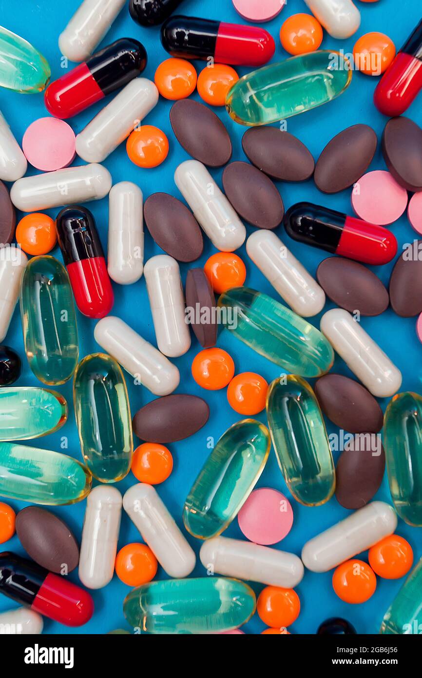 multicolored pills texture on blue background Stock Photo - Alamy