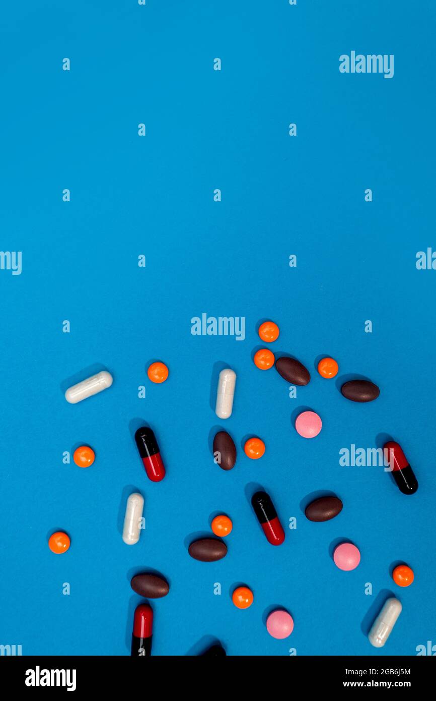 multicolored pills texture on blue background Stock Photo - Alamy