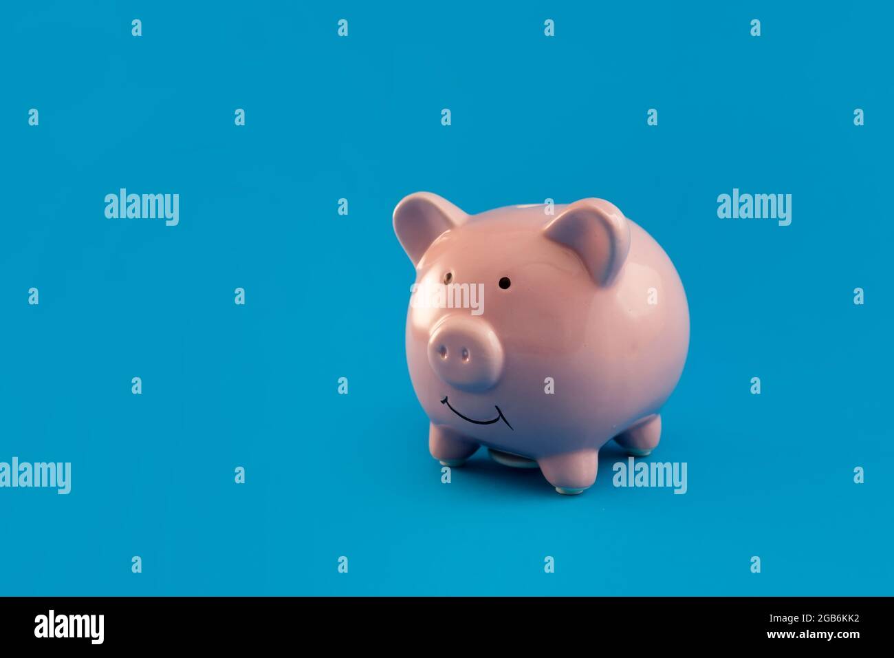 red piggy bank on blue background Stock Photo - Alamy