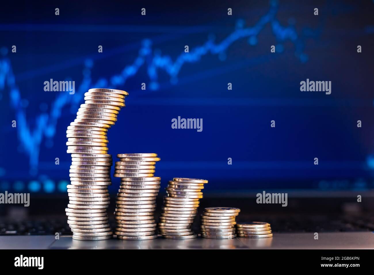 coins in the form of a graph on the background of a laptop graphics ...