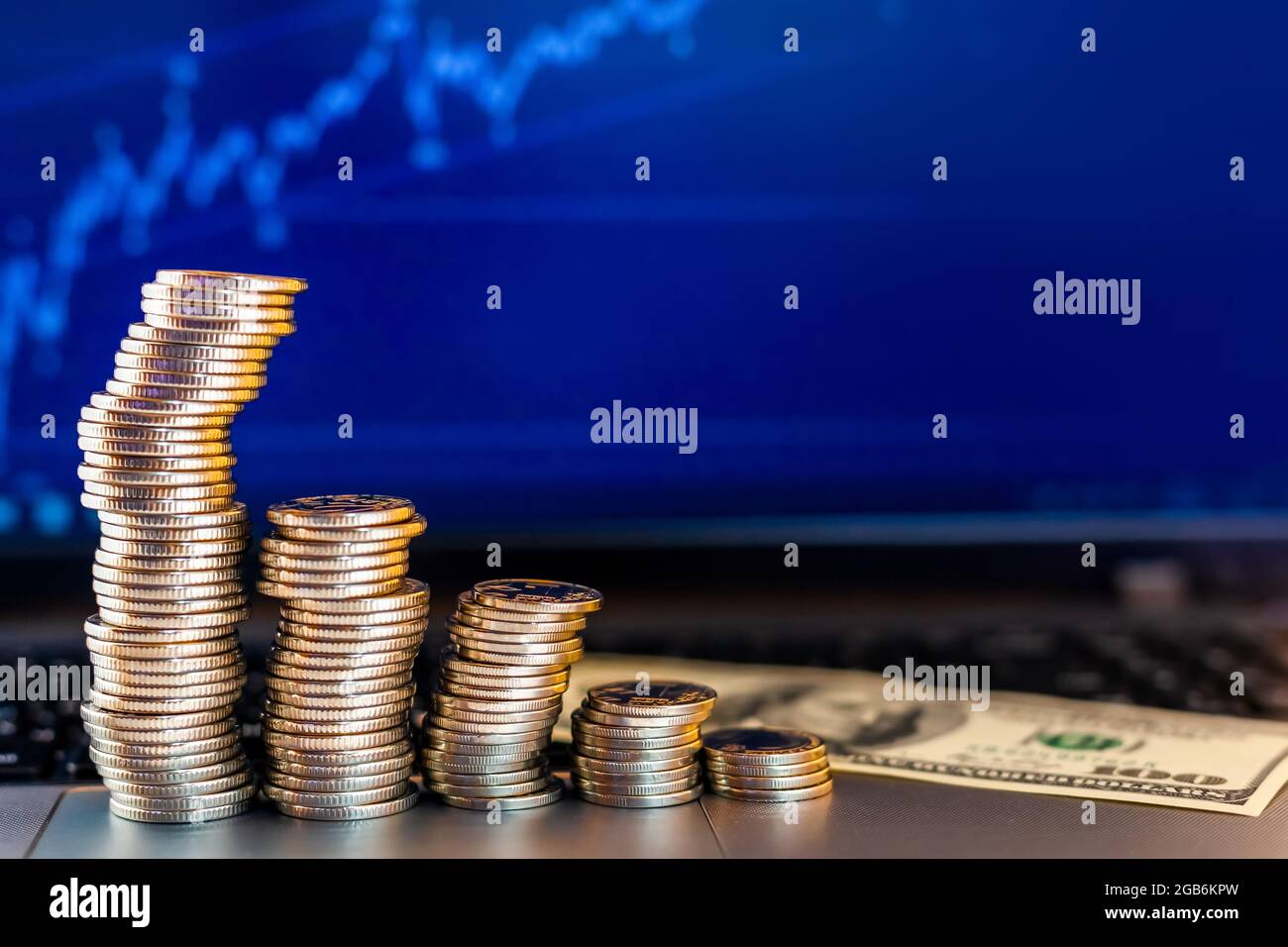 coins in the form of a graph on the background of a laptop graphics ...