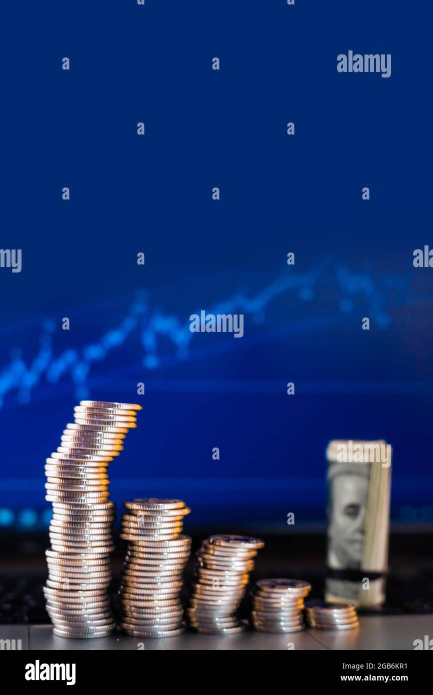 coins in the form of a graph on the background of a laptop graphics ...