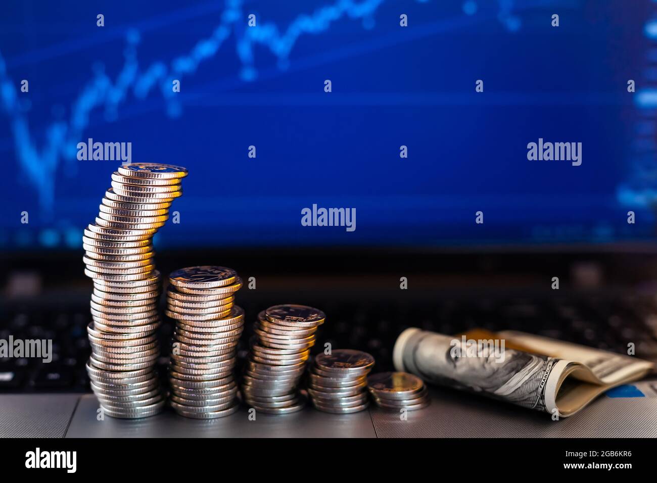 coins in the form of a graph on the background of a laptop graphics ...