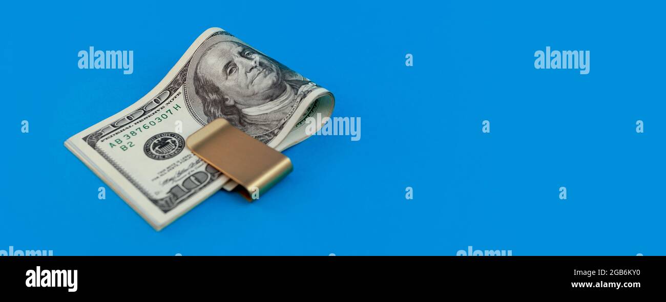 Money clip with dollar bills on blue panorama background Stock Photo ...