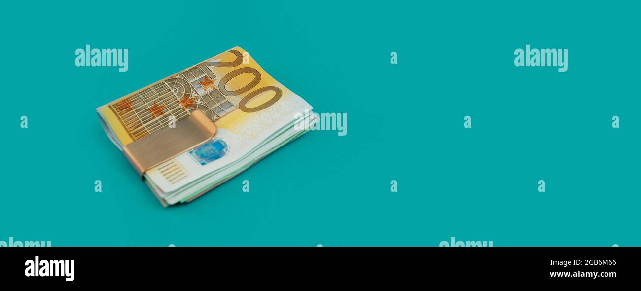 Money clip with euro bills on blue background Stock Photo - Alamy