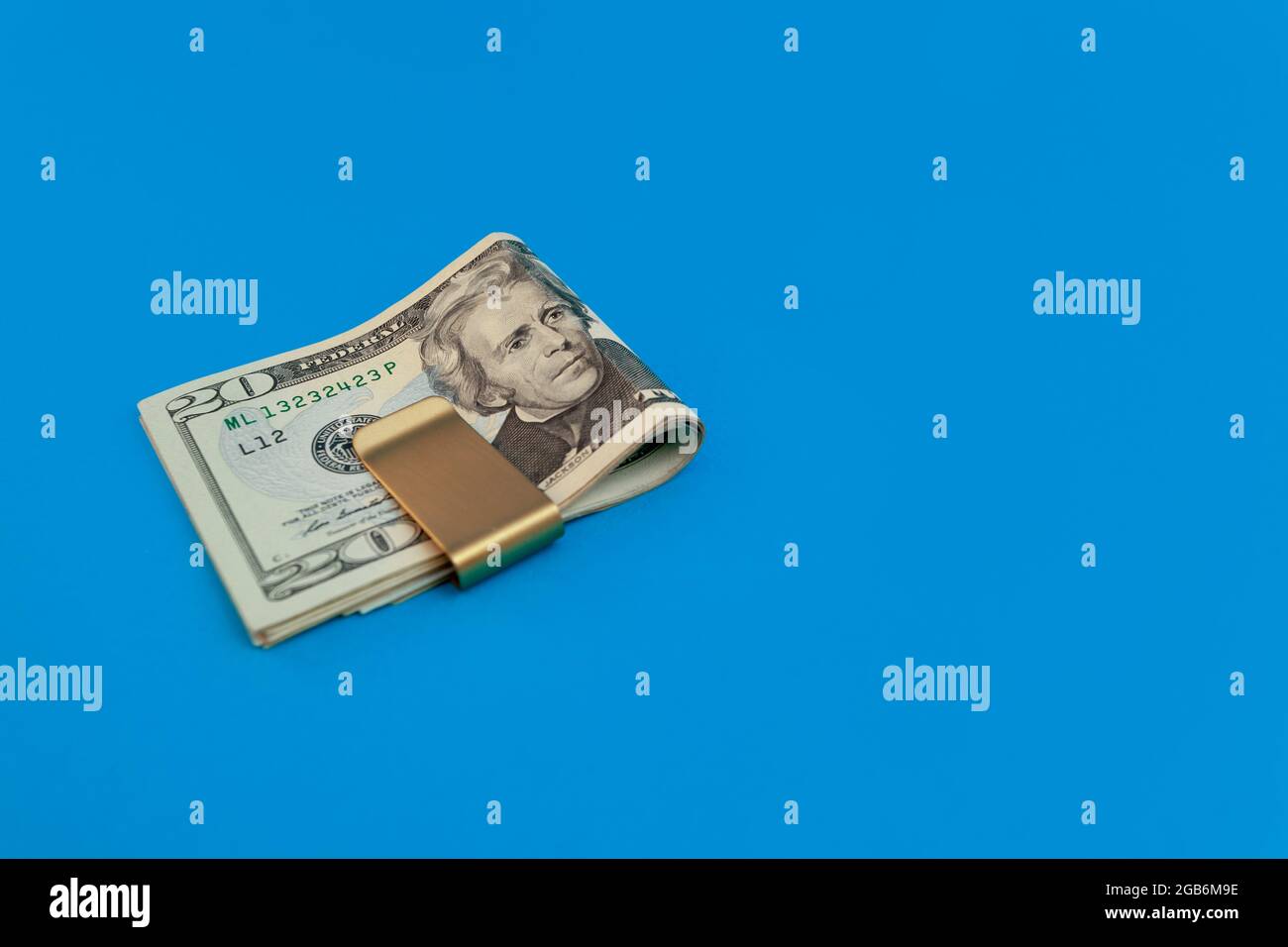 Money clip with dollar bills on blue background Stock Photo - Alamy