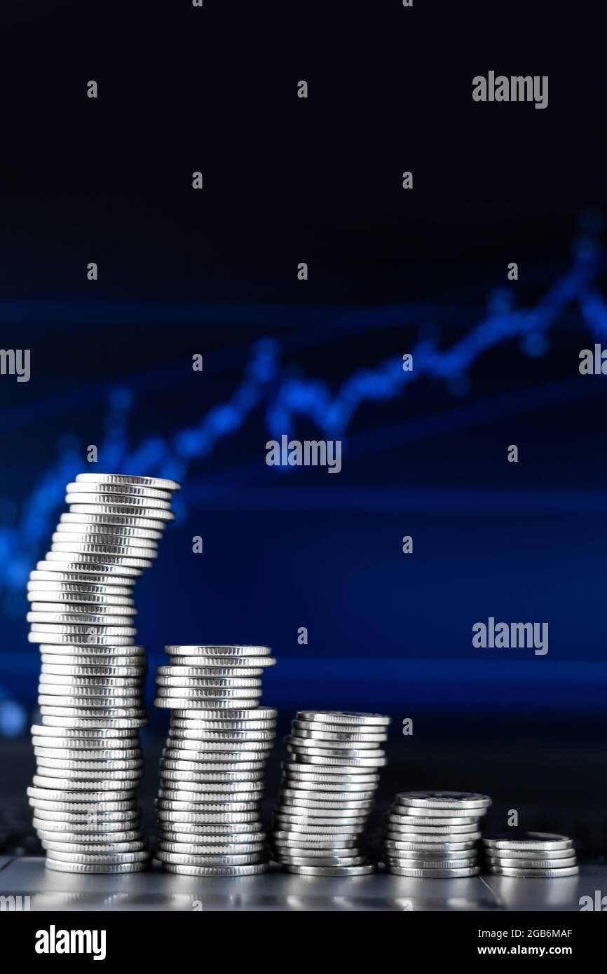 coins in the form of a graph on the background of a laptop graphics ...