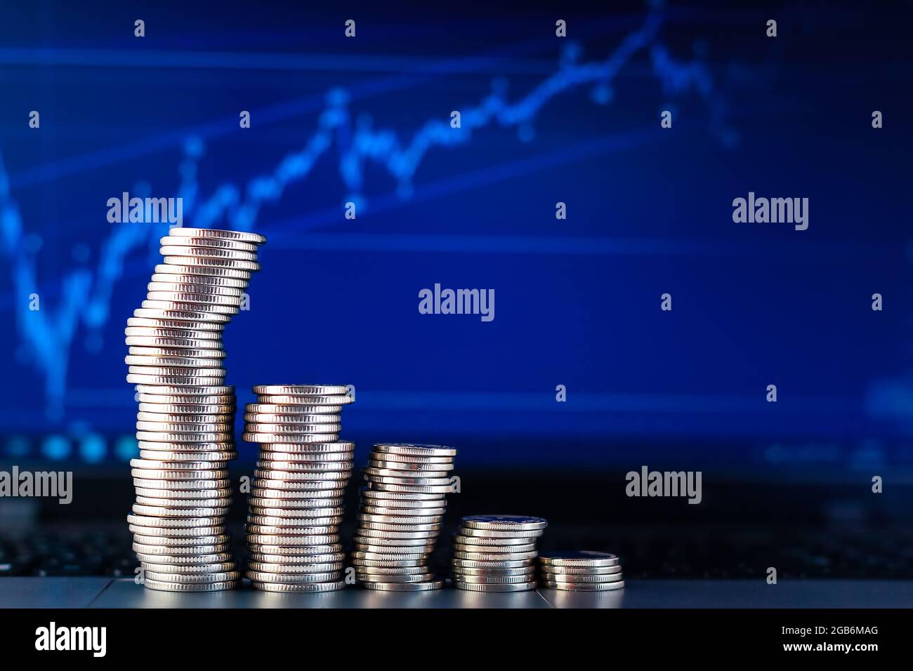 coins in the form of a graph on the background of a laptop graphics ...