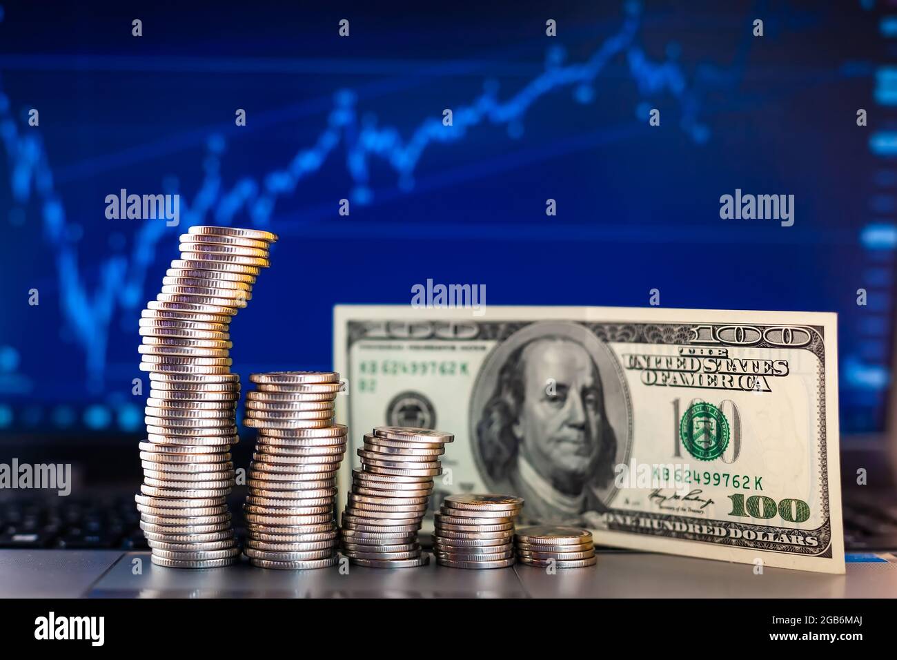 coins in the form of a graph on the background of a laptop graphics ...