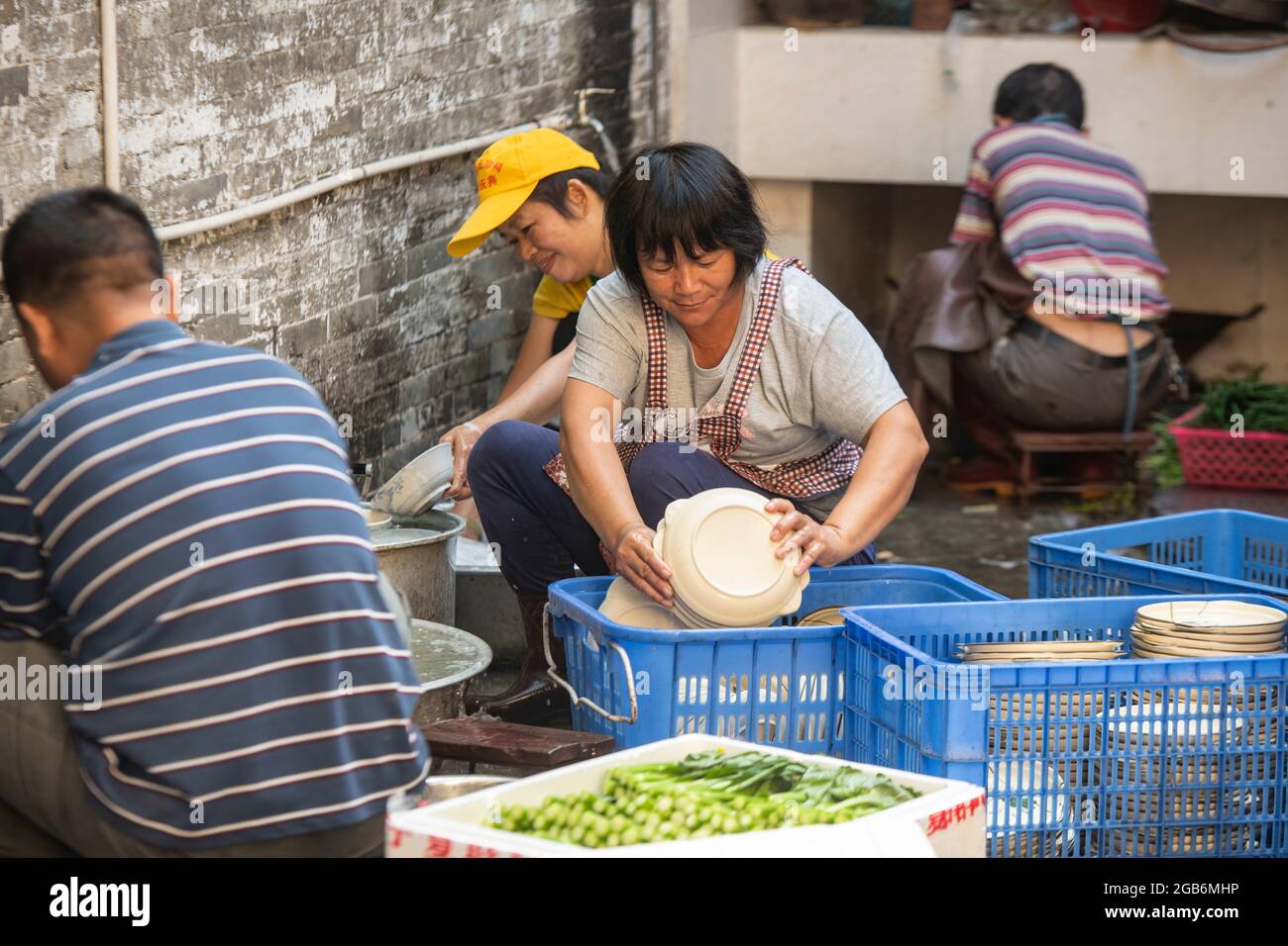 Families wash up their crockery, chopsticks and cutlery inside the ...