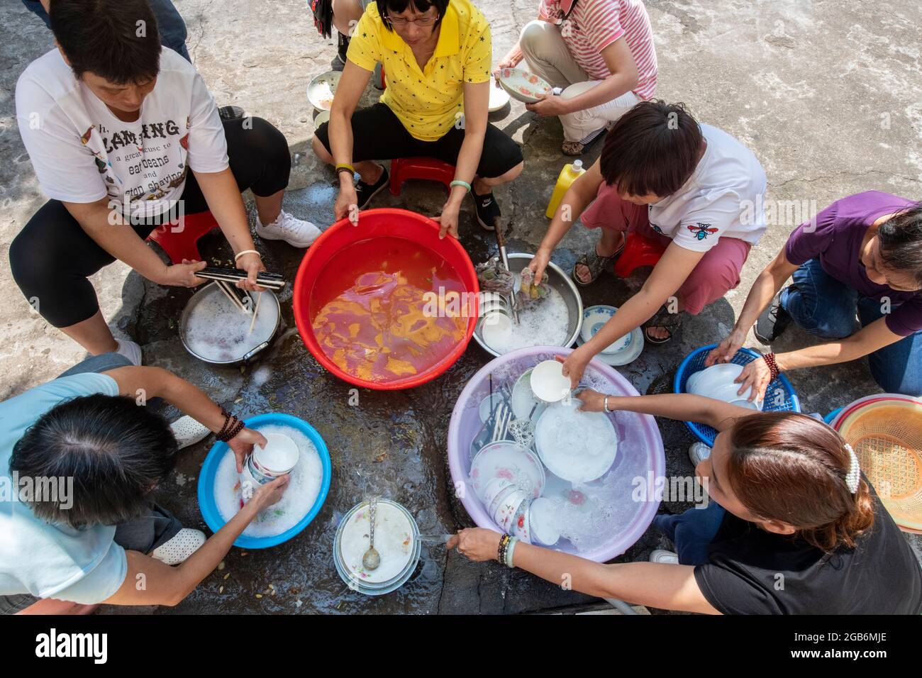 Women wash up their crockery, chopsticks and cutlery inside the Ancient ...